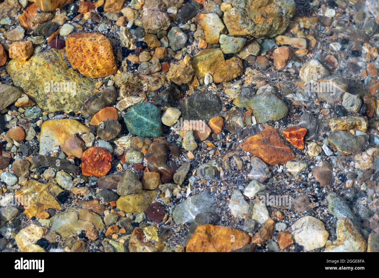 Coloured rhyolite rock in a stream, Landmannalaugar, Fjallabak ...