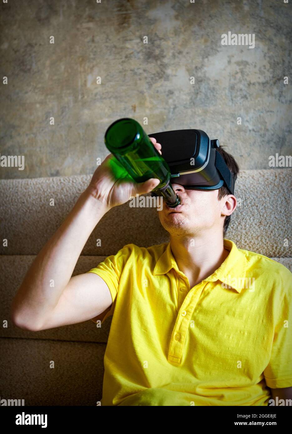 Young Man in VR Glasses drink a Beer on the Sofa Stock Photo - Alamy