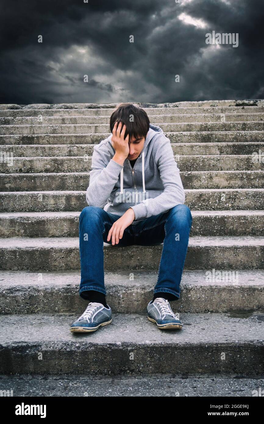 Sad Young Man sit on the Stairs Stock Photo - Alamy