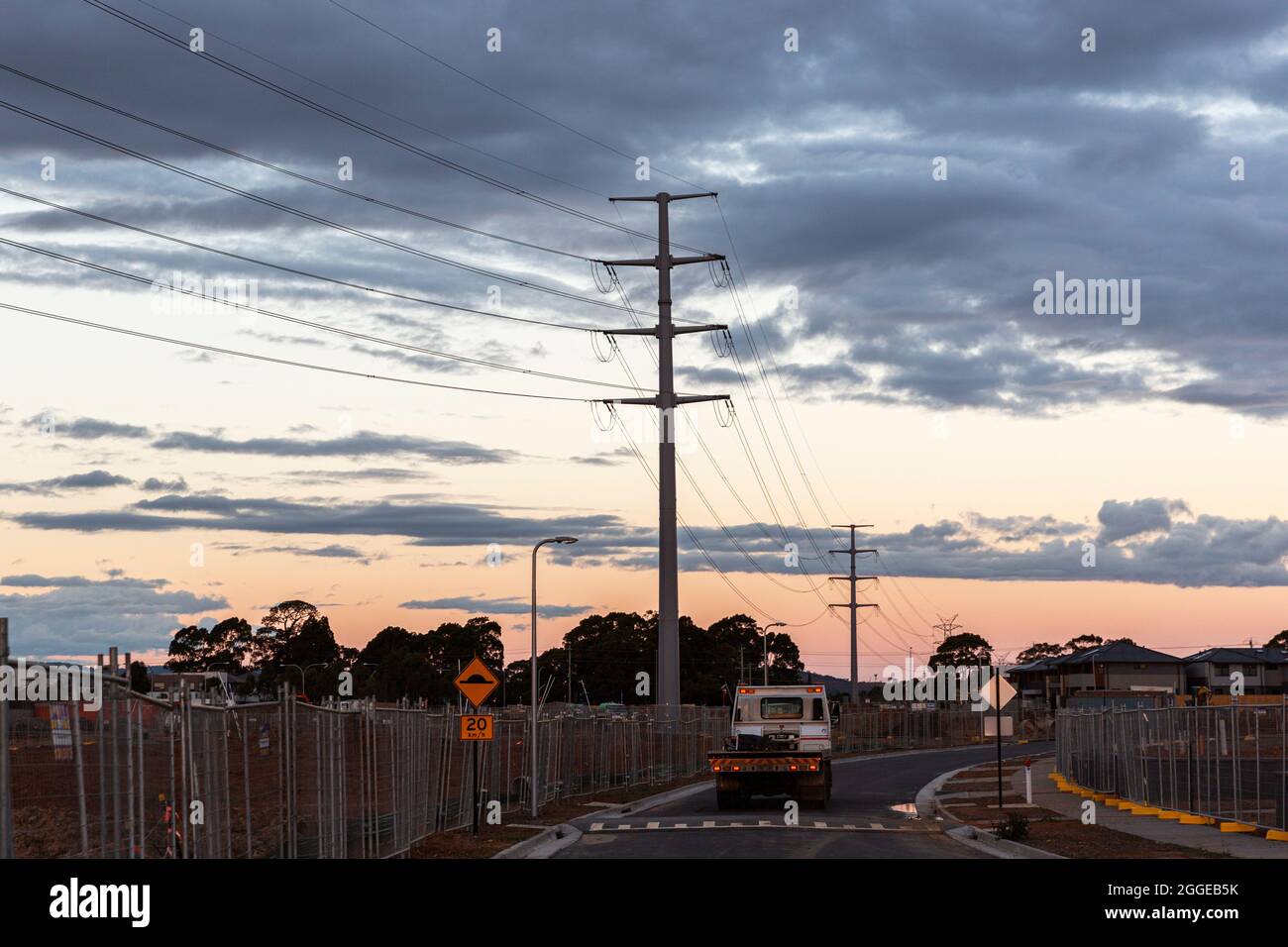 Dusk sky over road in suburbs with power tower above Stock Photo - Alamy