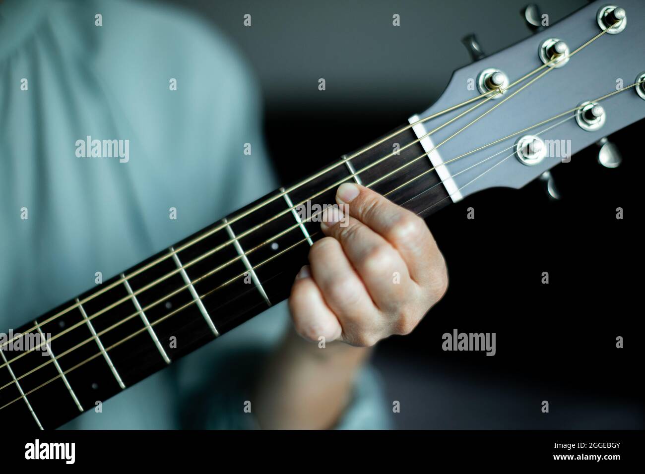 Close focus on hand of woman practices to play cords of acoustic 6 ...