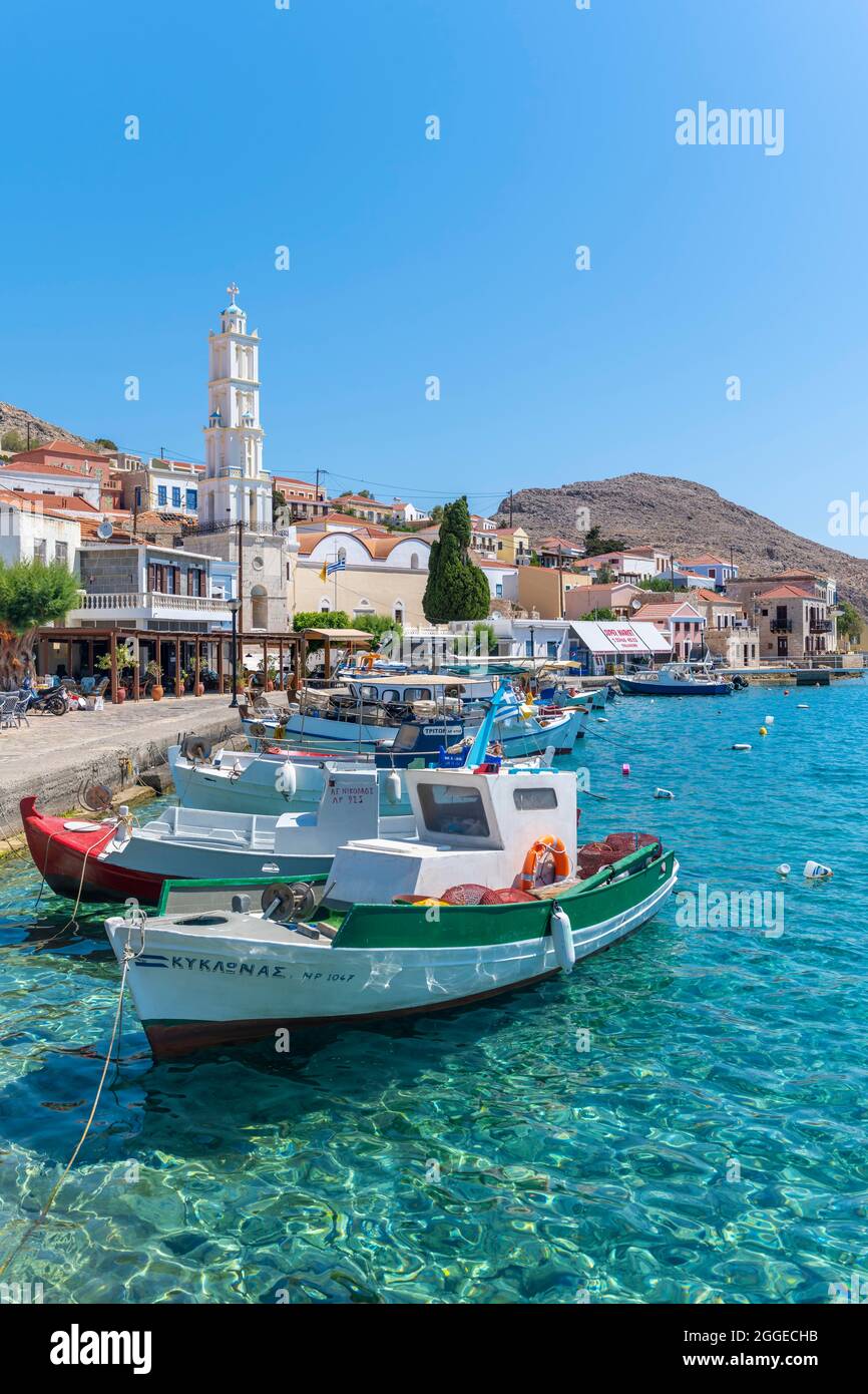 Fishing boats in the harbour of Halki with turquoise water, promenade ...