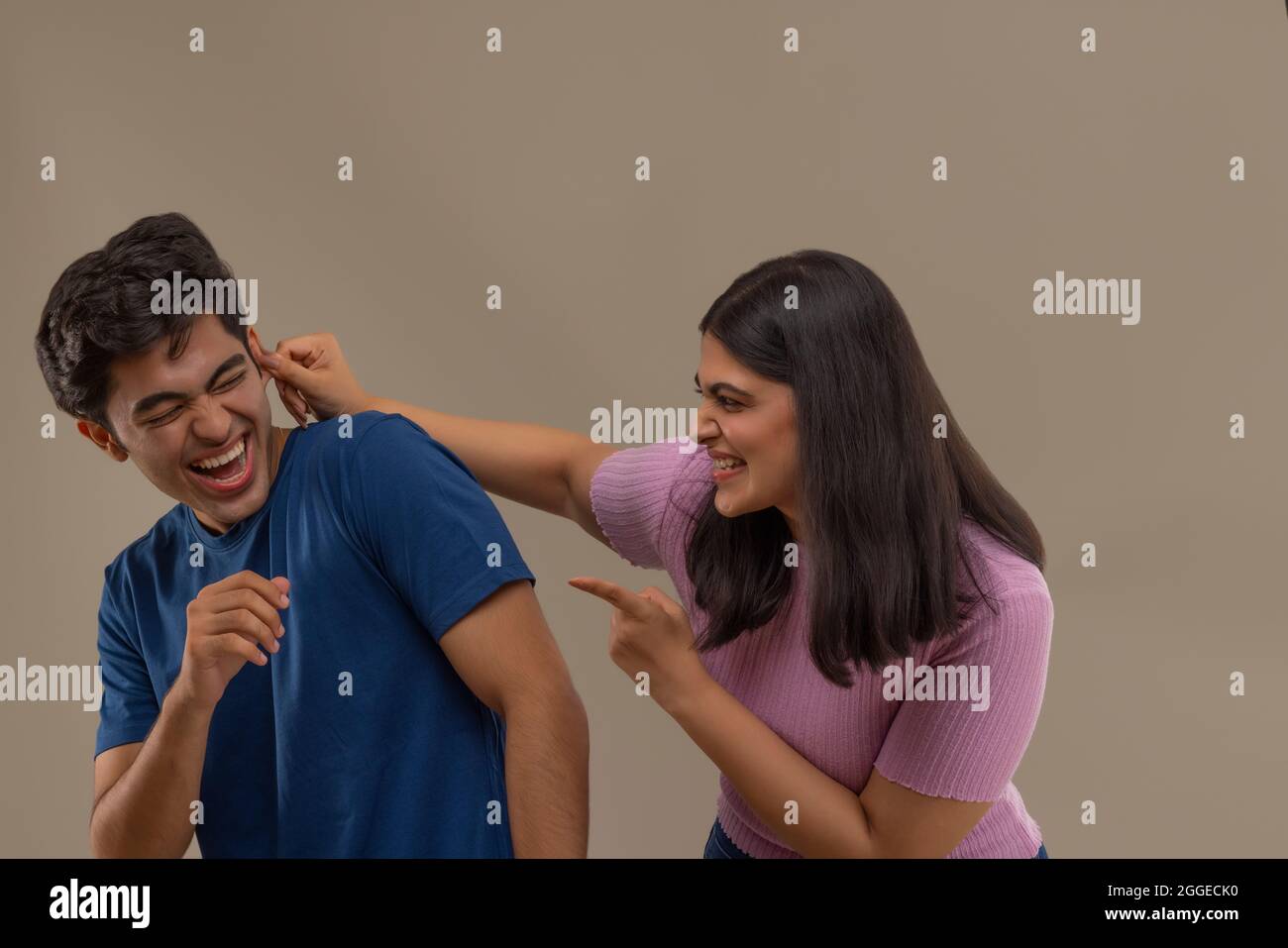 A YOUNG WOMAN PLAYFULLY REBUKING YOUNGER BROTHER Stock Photo - Alamy
