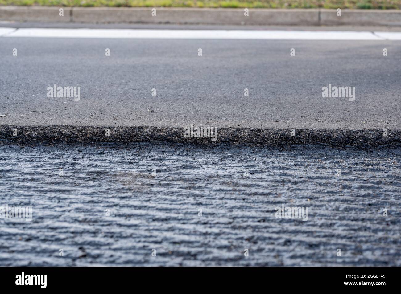 low angle selective focus on asphalt overlay paving on top of a ...