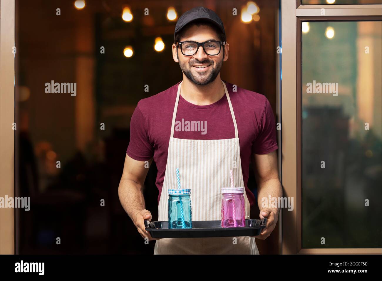 A CHEERFUL WAITER SERVING BEVERAGES WHILE WORKING Stock Photo - Alamy