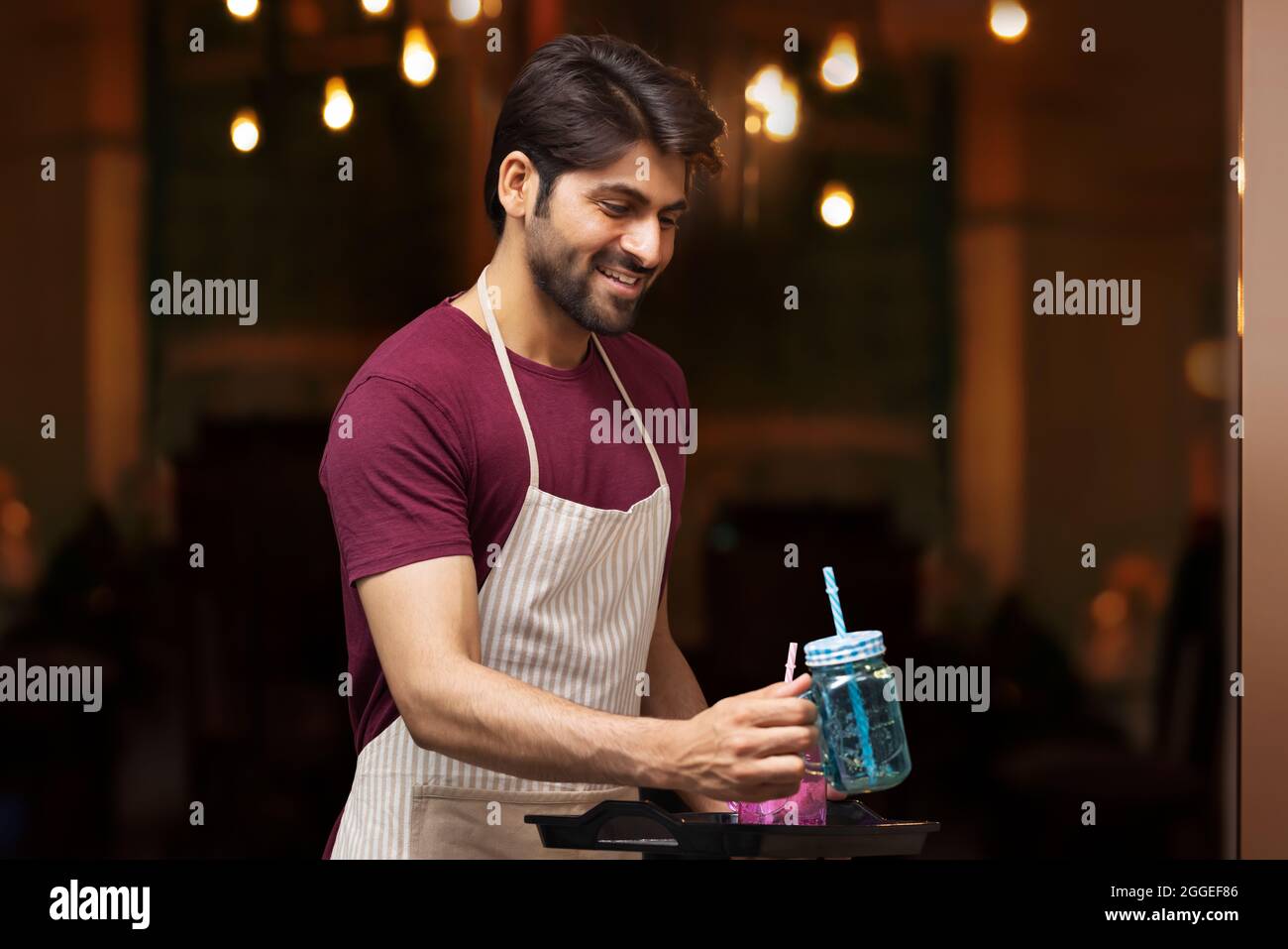 A HAPPY WAITER SERVING BEVERAGES IN A RESTAURANT Stock Photo - Alamy
