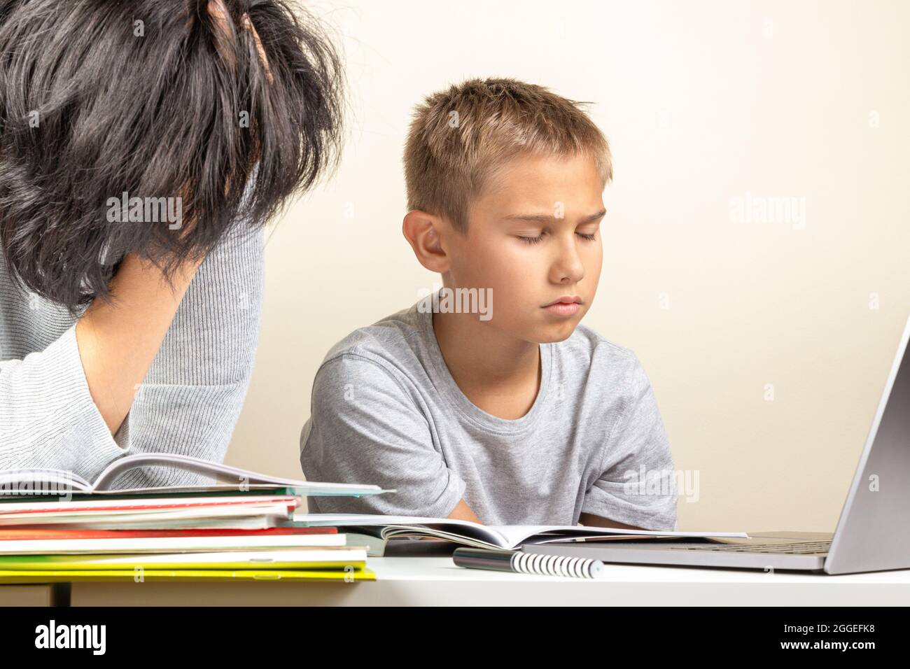 Disappointed frustrated tired exhausted sad kid sits at table with ...