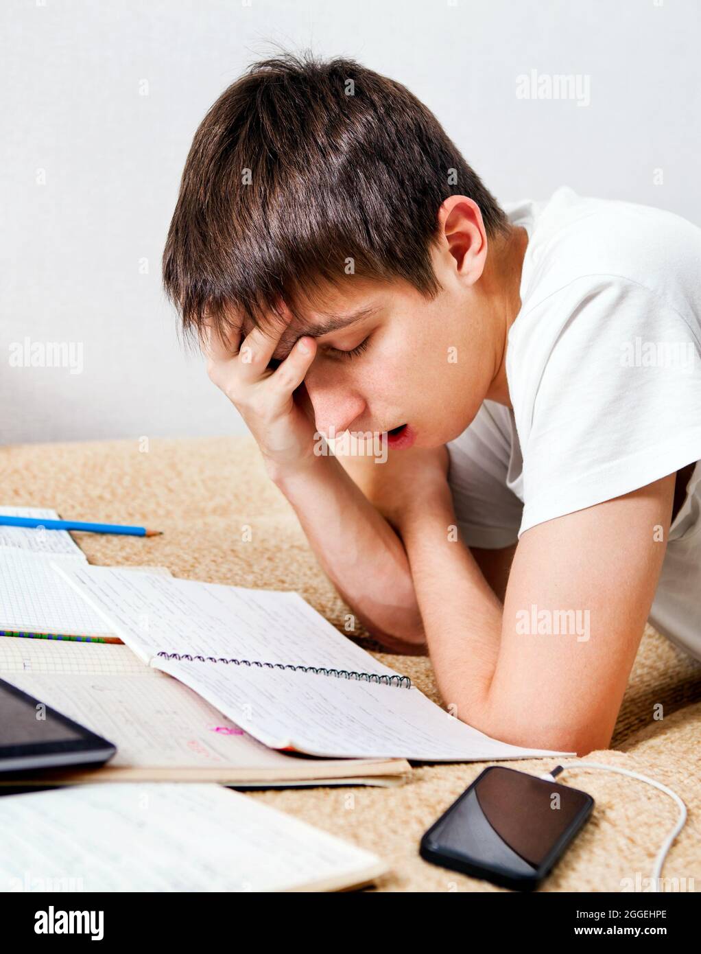 Teen doing homework on bed hi-res stock photography and images - Alamy