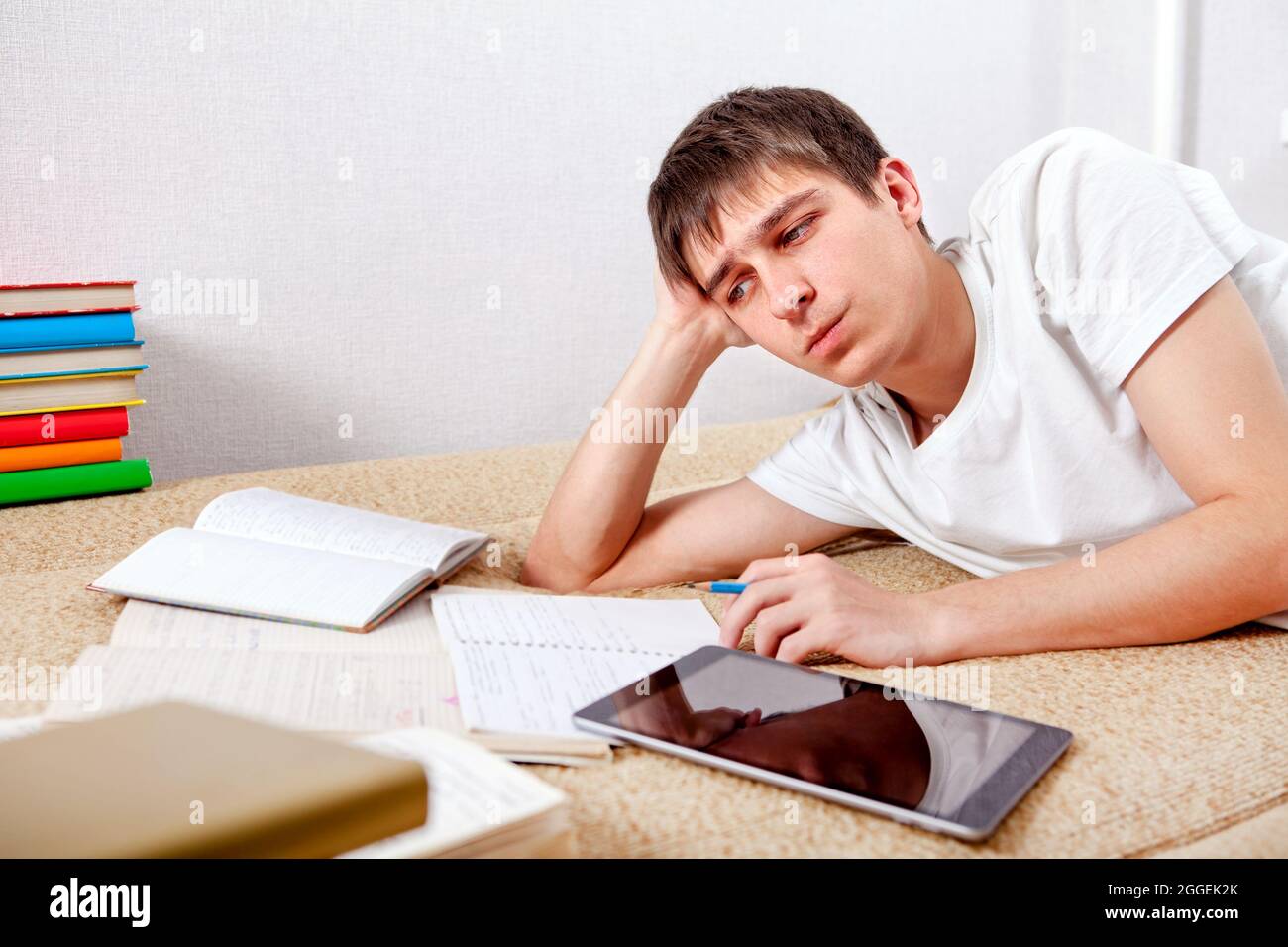 Tired Student doing Homework on the Sofa Stock Photo - Alamy