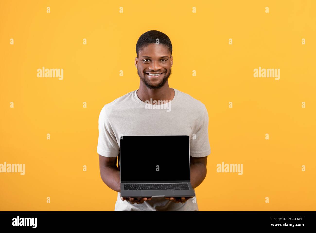 New website. Excited black man holding laptop computer with black ...