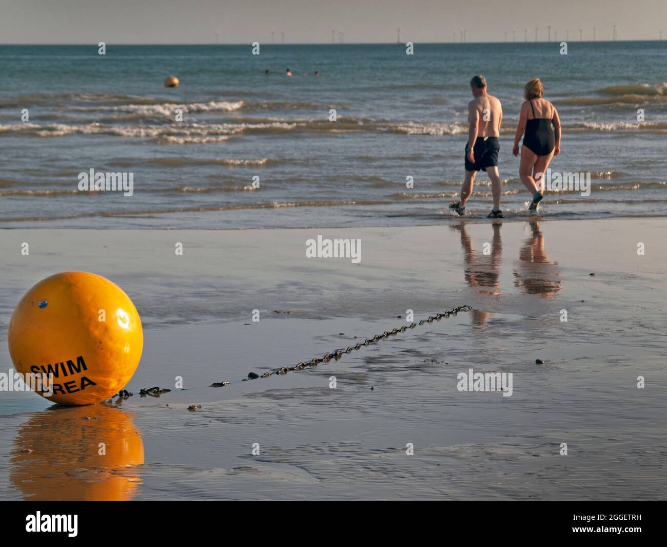 A couple walk into the sea for a swim at Brighton Stock Photo - Alamy