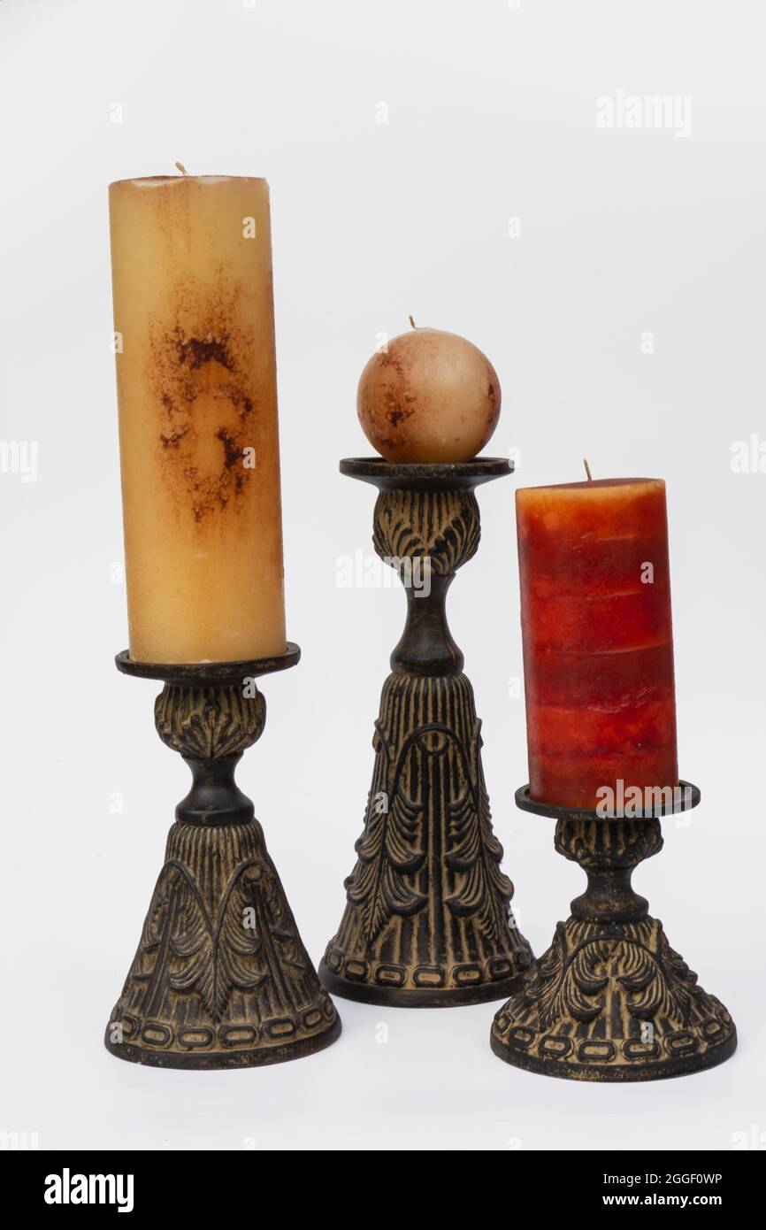 antique candlesticks made of bronze or iron, and colored candles in ...