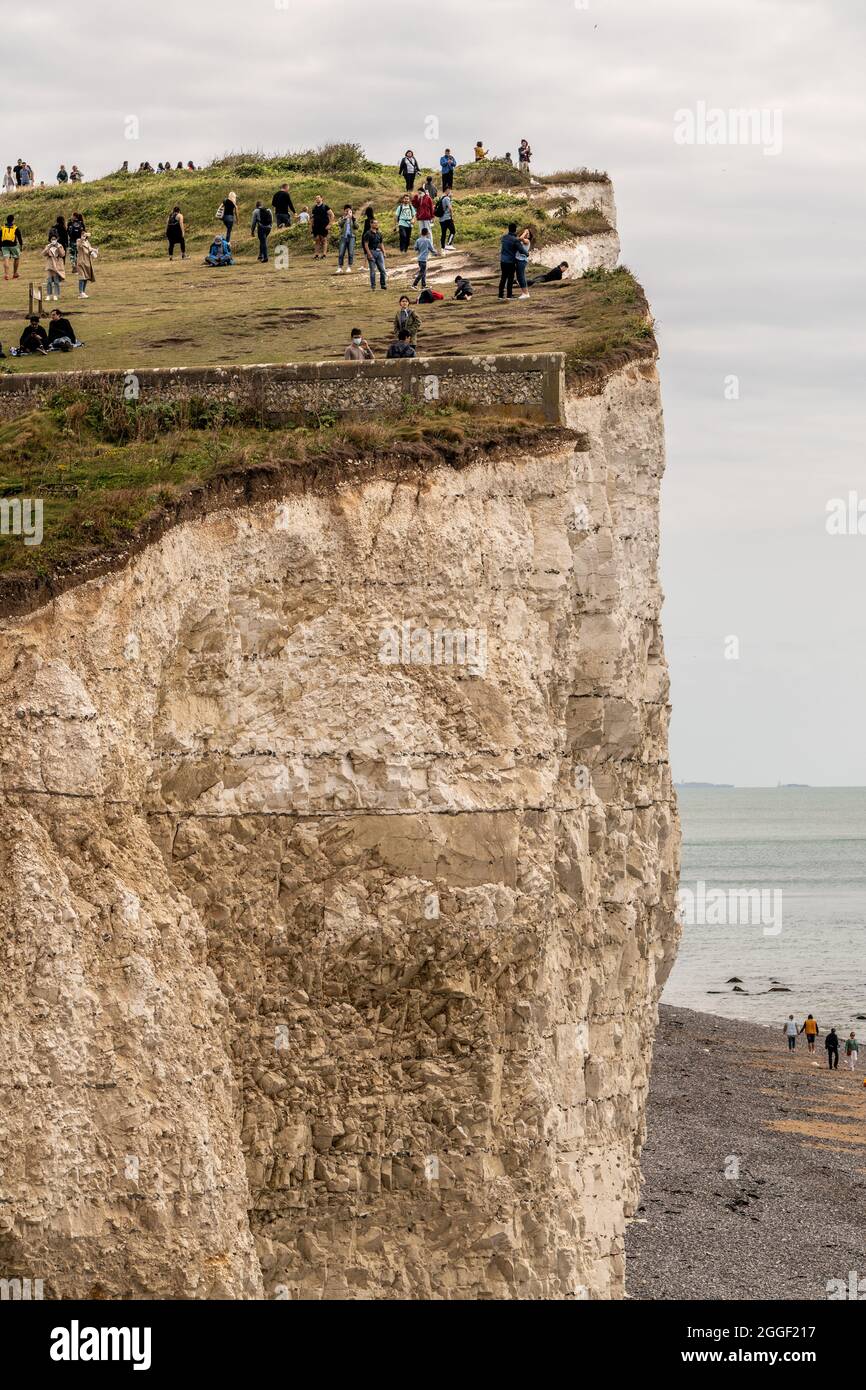 People stand precariously close to the crumbling cliff edge at Beachy ...