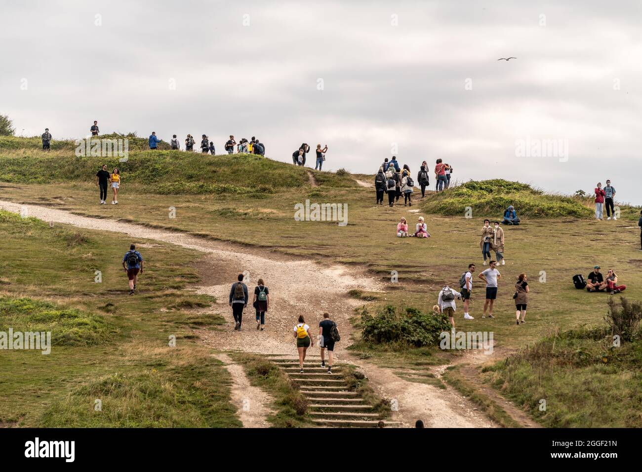 People stand precariously close to the crumbling cliff edge at Beachy ...