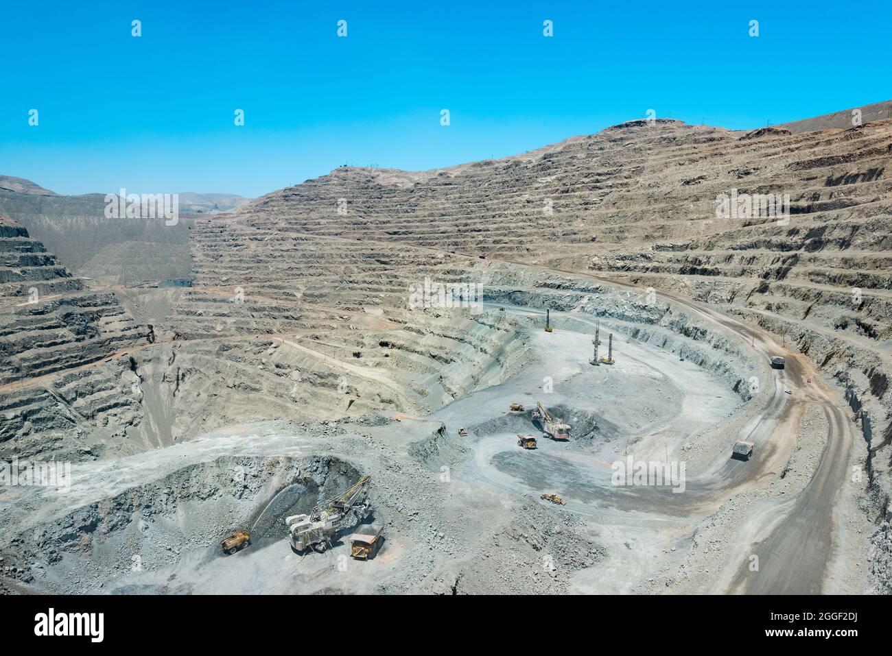 Electric rope shovel loading a dump trucks at a copper mine in Chile ...