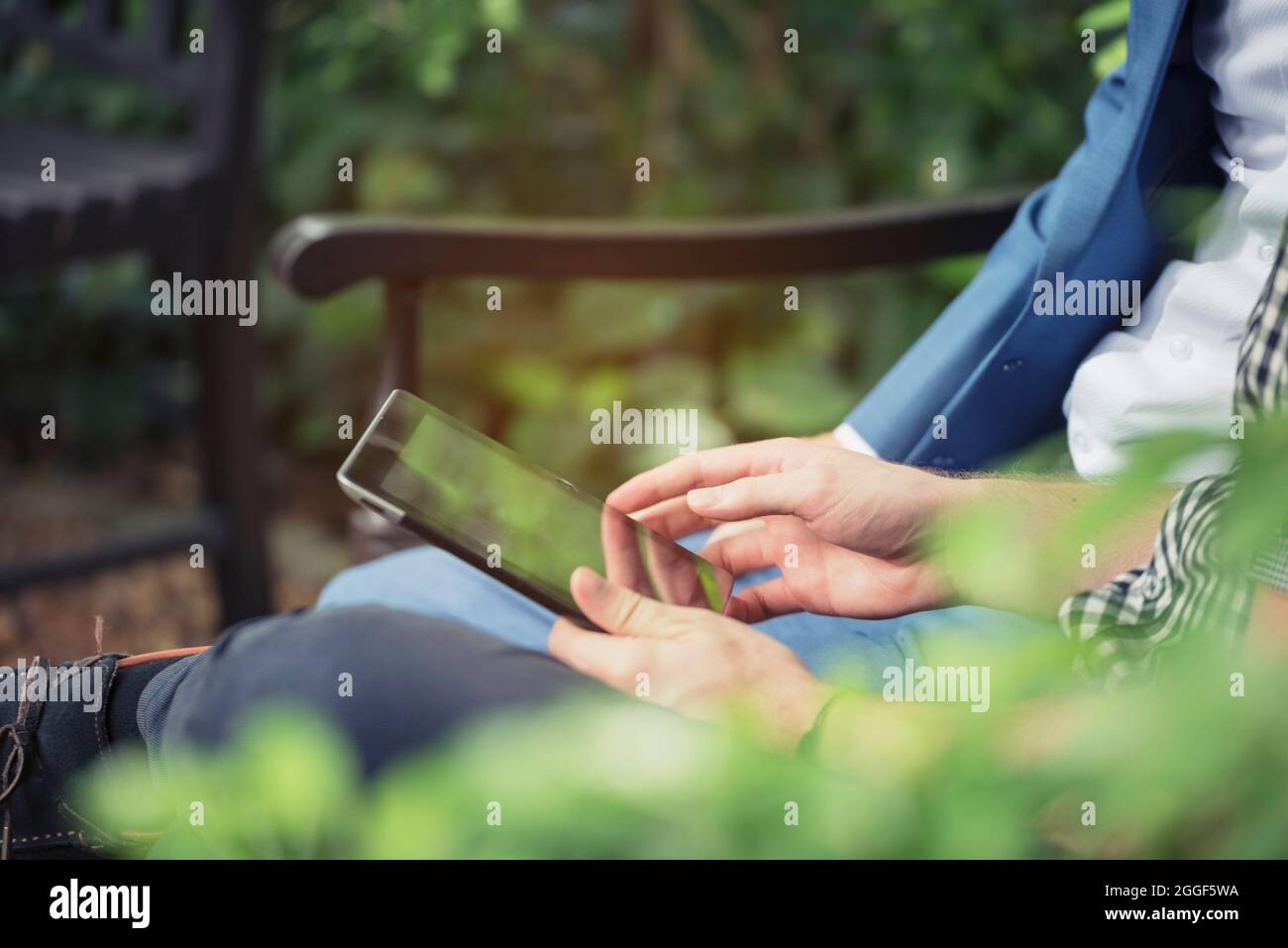 Casual Business man using smart tablet working outdoor in the park ...