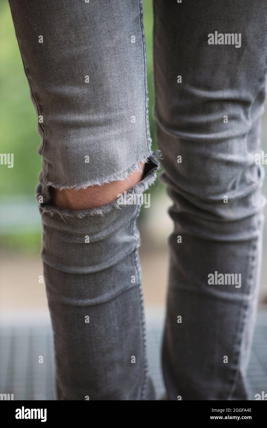 Vertical closeup of gray ripped jeans Stock Photo - Alamy