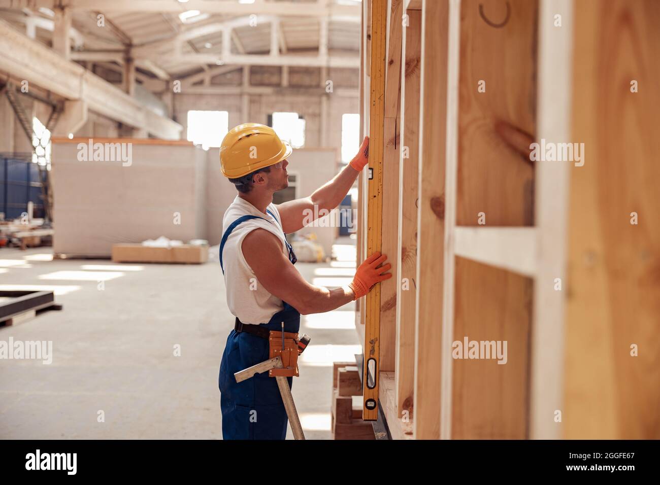 Male builder measuring wood siding of construction cabin Stock Photo ...