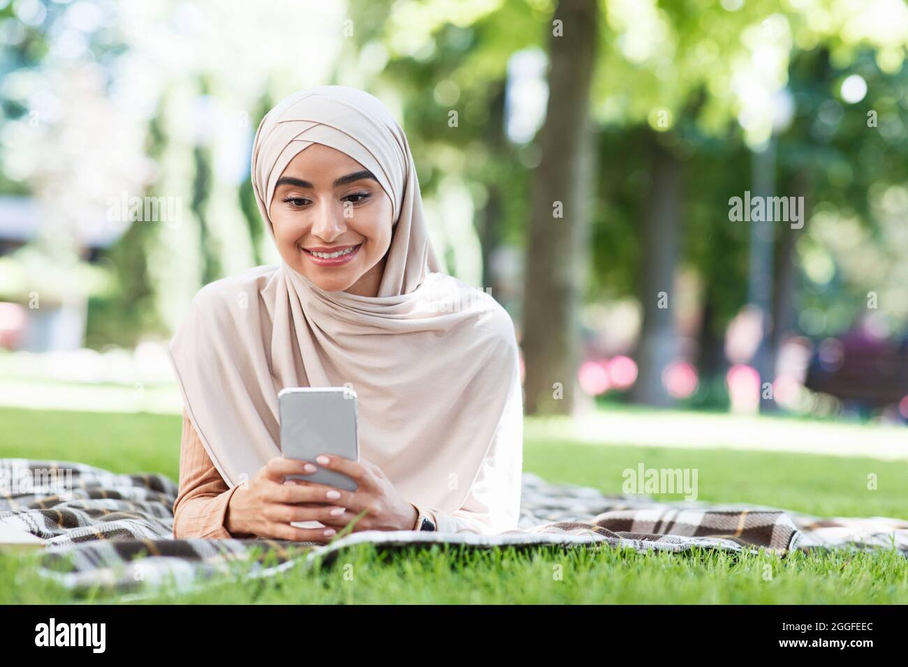 Happy attractive young arab islamic female blogger in hijab chatting on ...