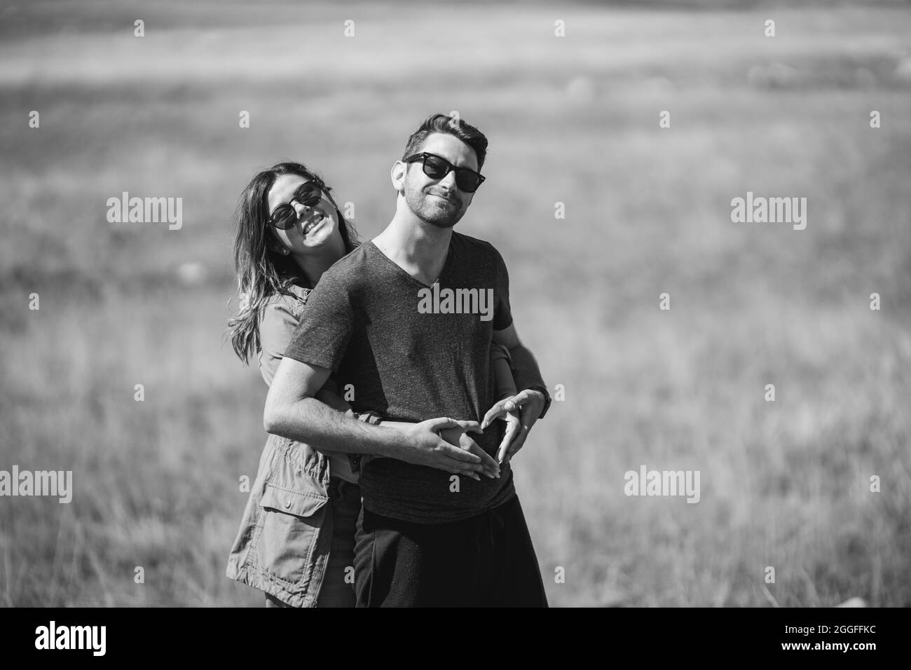 Romantic view of the Caucasian young couple hugging in the field in ...