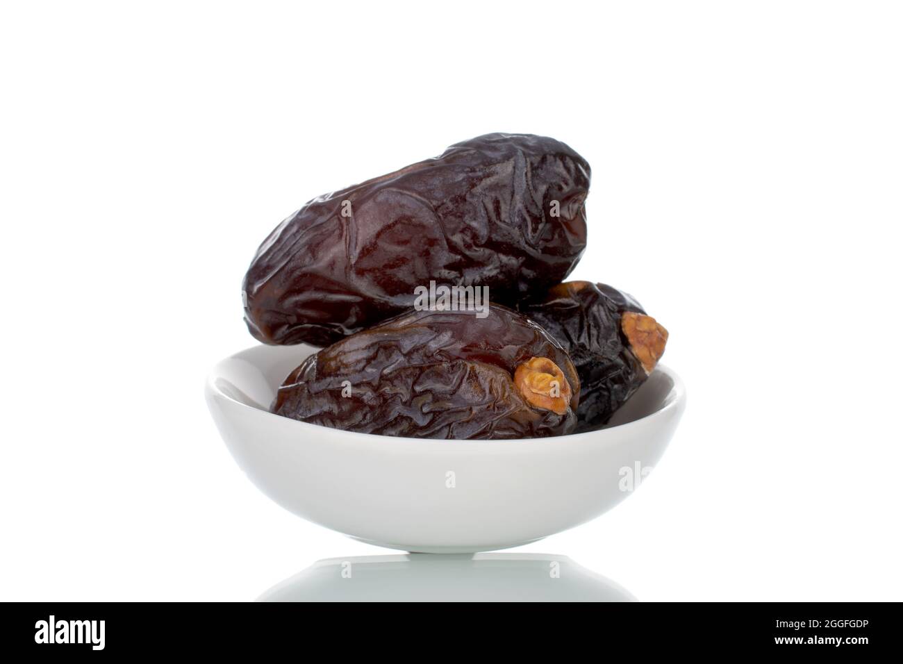 Several royal dates in a white ceramic dish, close-up, isolated on ...