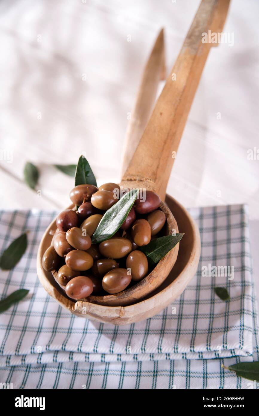 Presentation of a small group of black olives on wooden ladle Stock ...