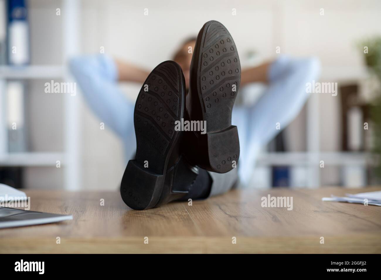 Millennial Arab office employee relaxing after work, putting legs on ...