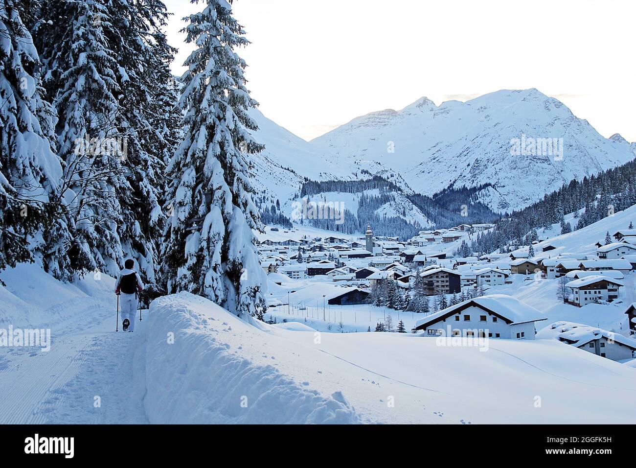 Woman Walking at the Road with view of Village of Lech, Austrian Alps ...