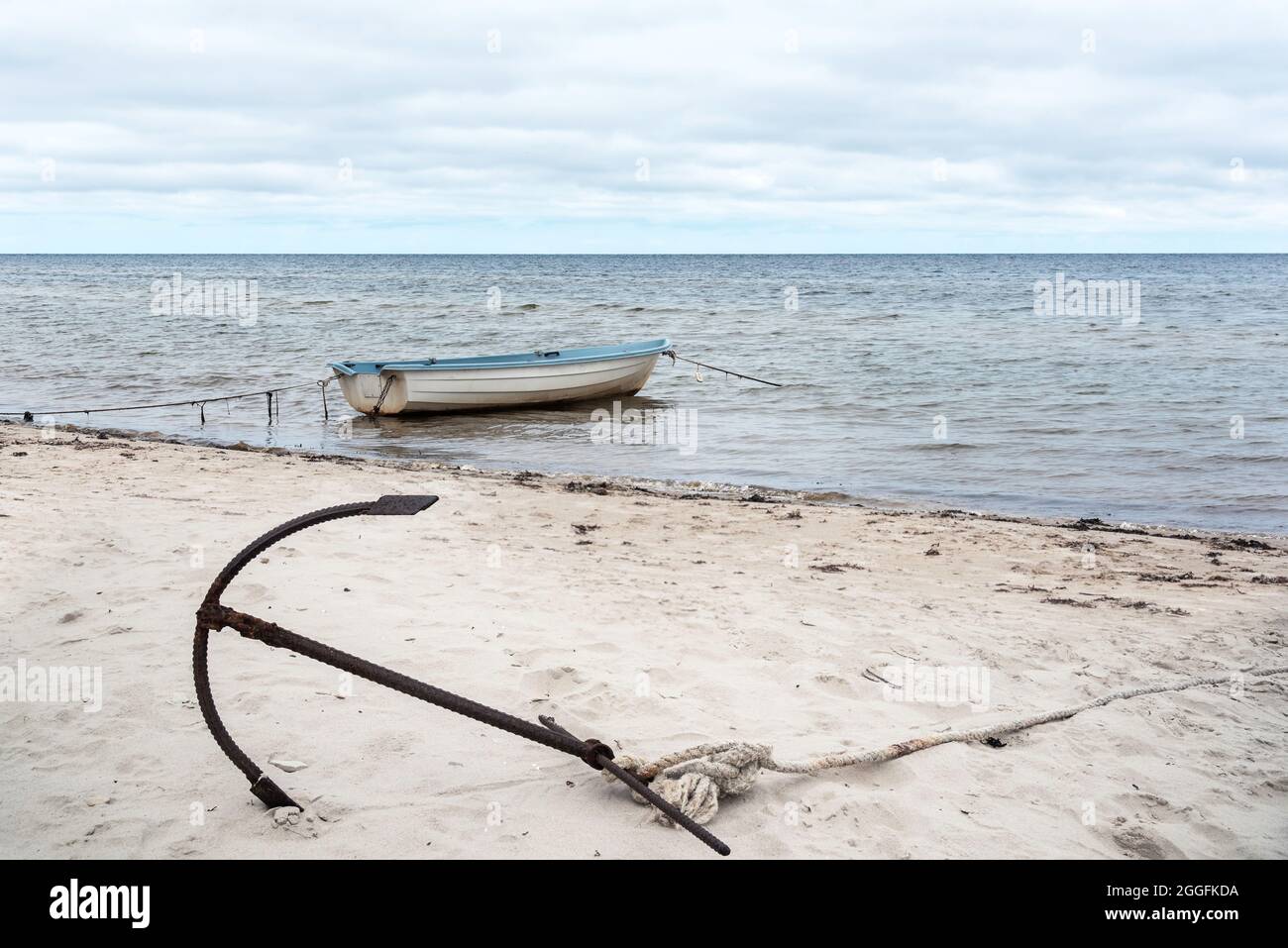 Fishing boat and anchor on a sea shore Stock Photo - Alamy