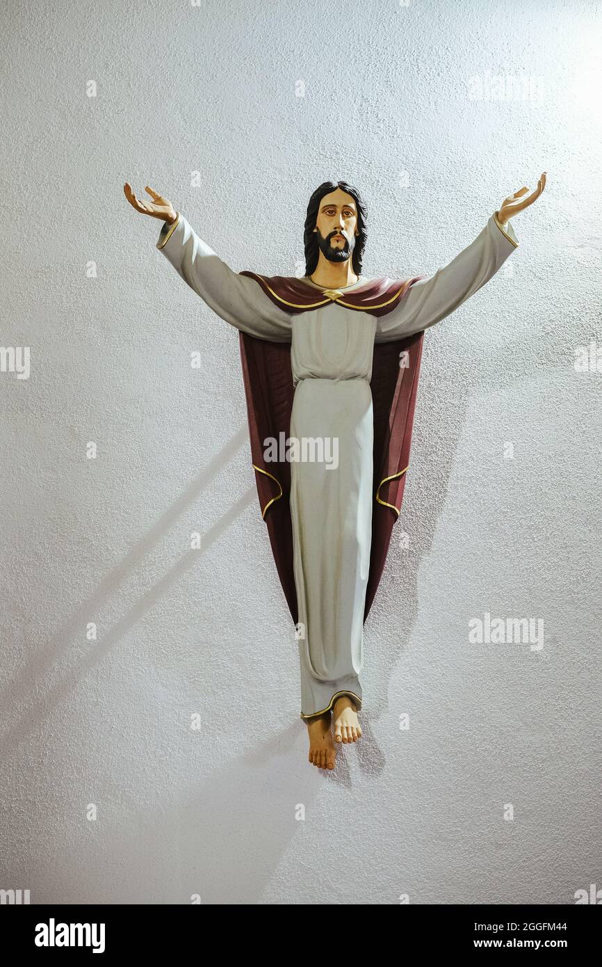 Figurine of Jesus Christ in the biblical robe with his hands raised up ...