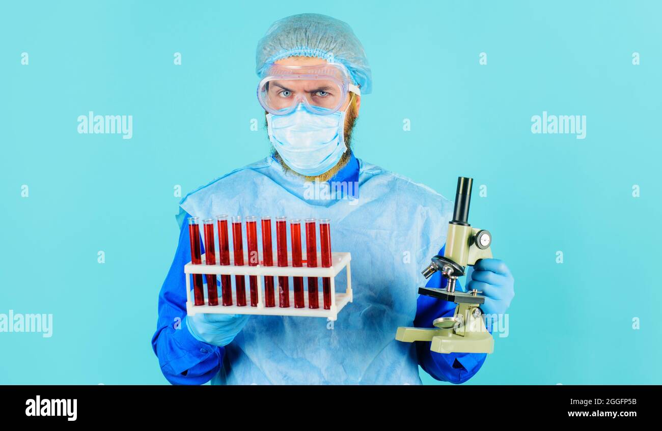 Doctor with test tubes and microscope analyzing blood sample. Scientist ...