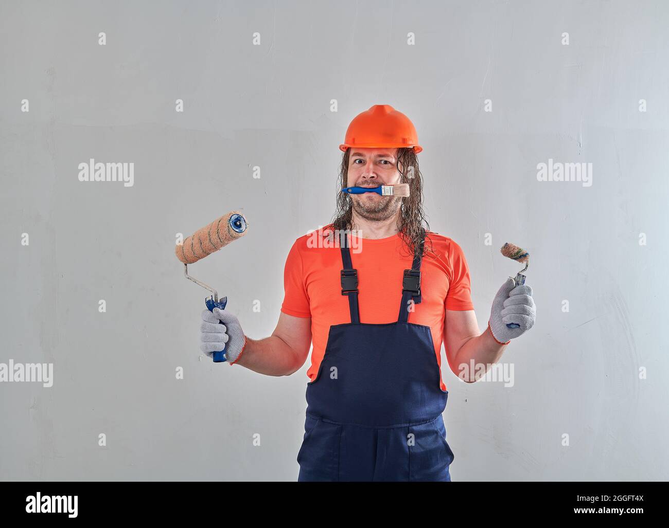 the foreman with paint rollers and a brush stands Stock Photo - Alamy