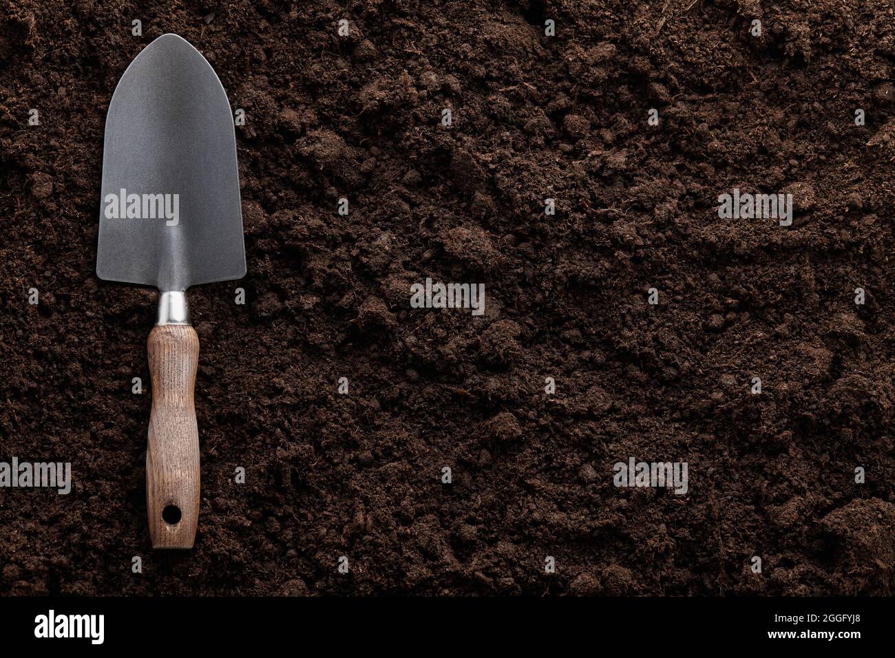 Garden trowel on soil background, close up view Stock Photo - Alamy