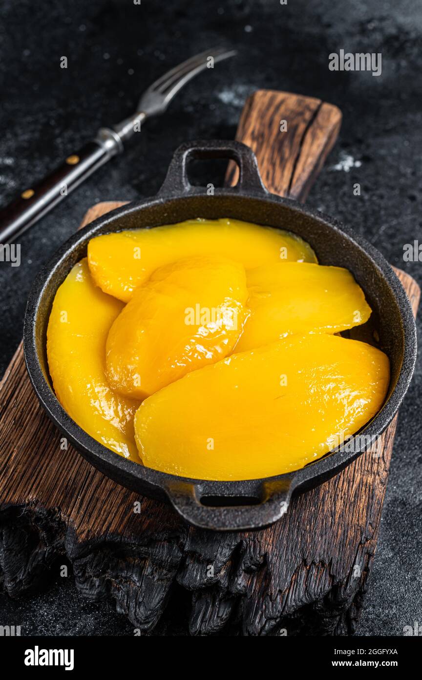 Canned mango slices in bowl. Black background. Top view Stock Photo - Alamy