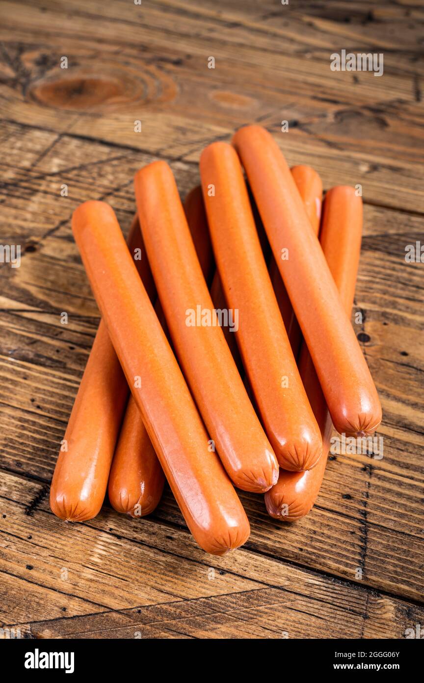 Raw frankfurter sausages on kitchen table. Wooden background. Top view ...