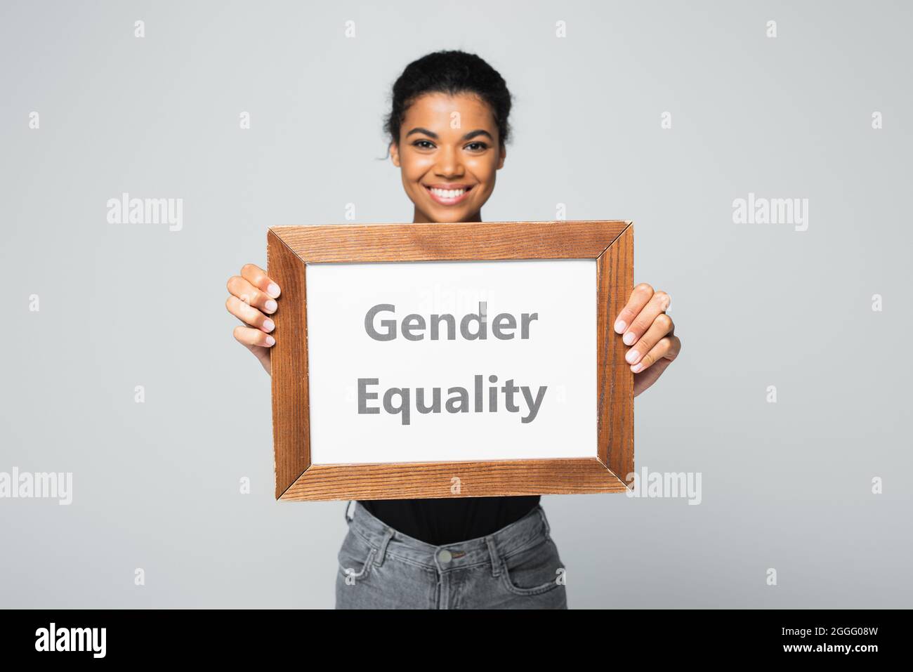 smiling african american woman holding placard with gender equality ...