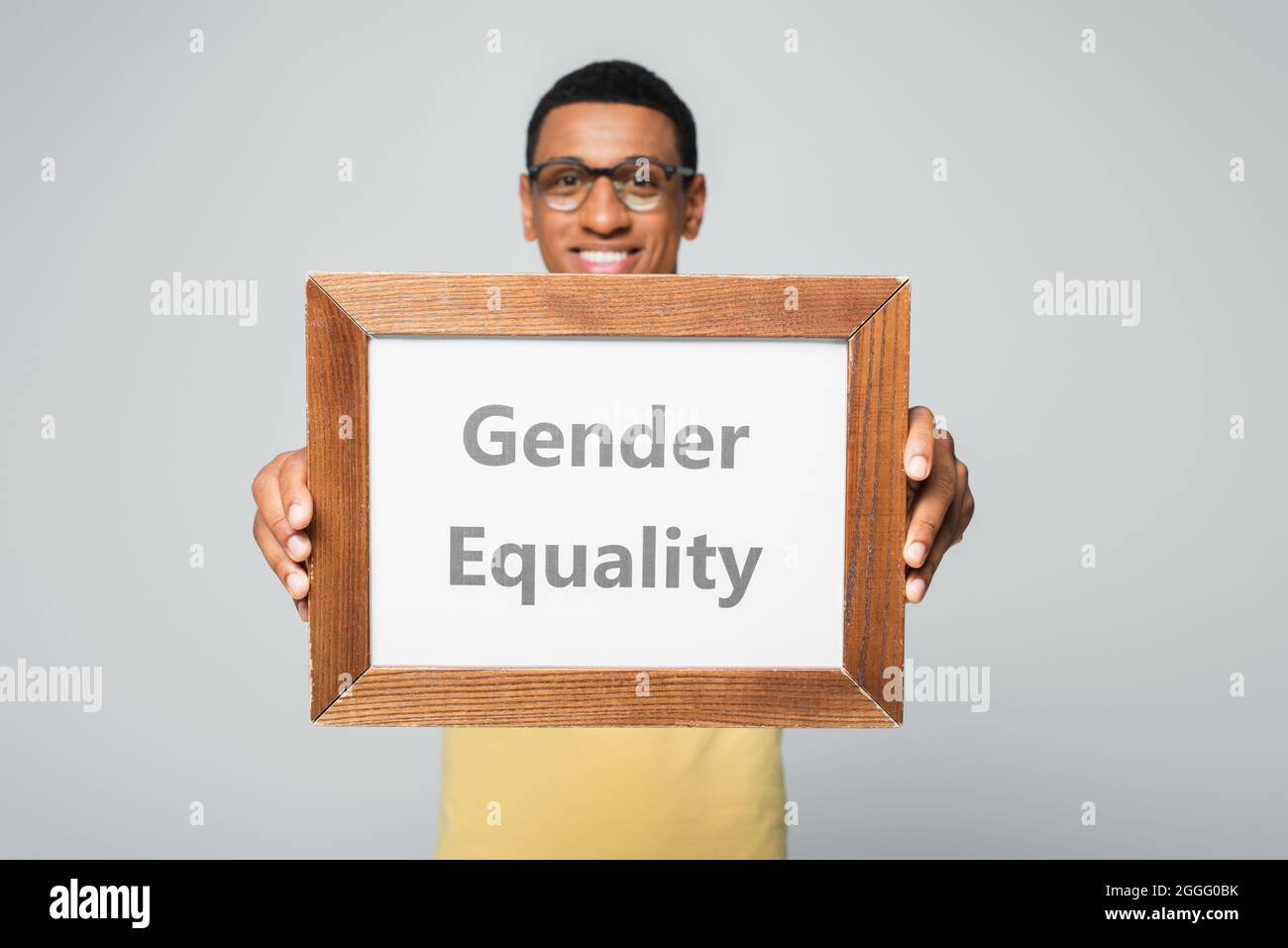 blurred and happy african american man holding placard with gender ...