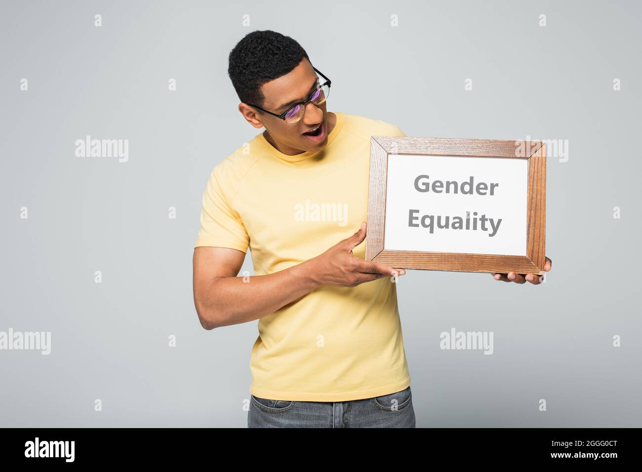 amazed african american man holding placard with gender equality ...
