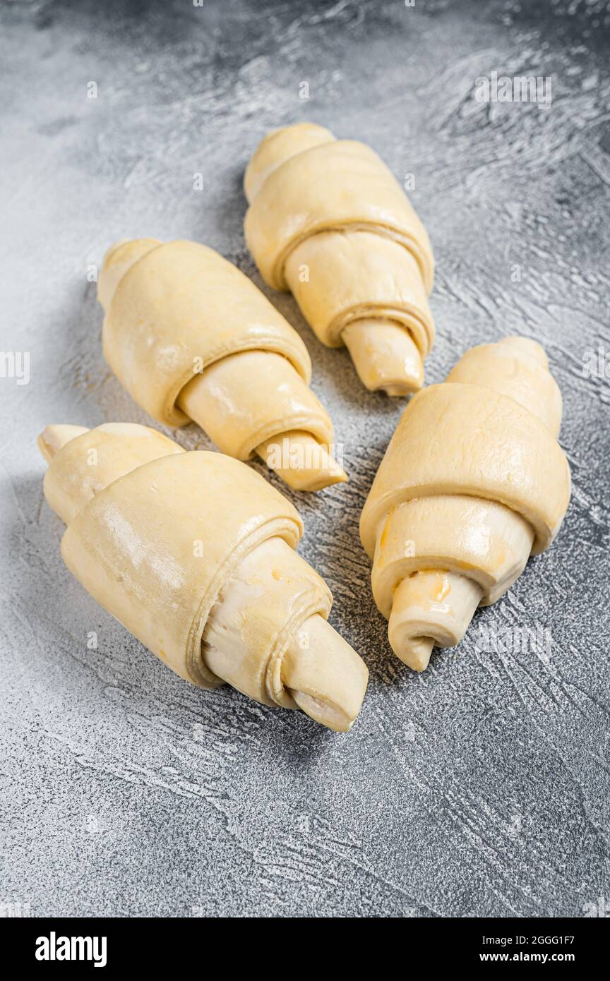 Raw unbaked croissant on kitchen table. White background. Top view ...