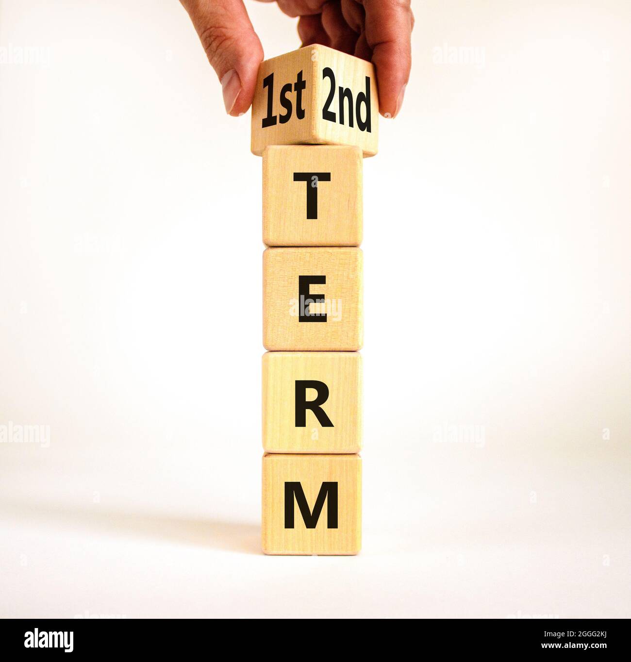 First or second term symbol. Businessman turns a cube and changes words ...