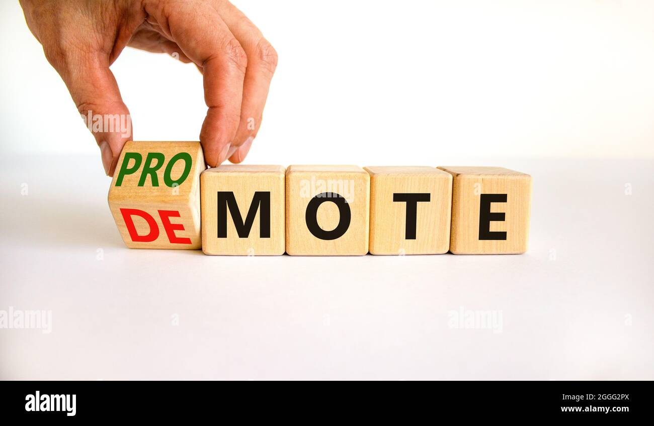 Promote or demote symbol. Businessman turns a cube and changes the word ...