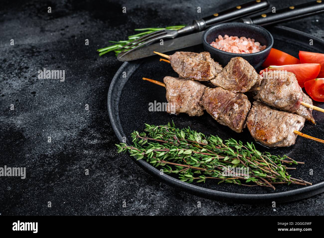 Roasted meat skewers shish kebab and vegetables on a plate. Black ...