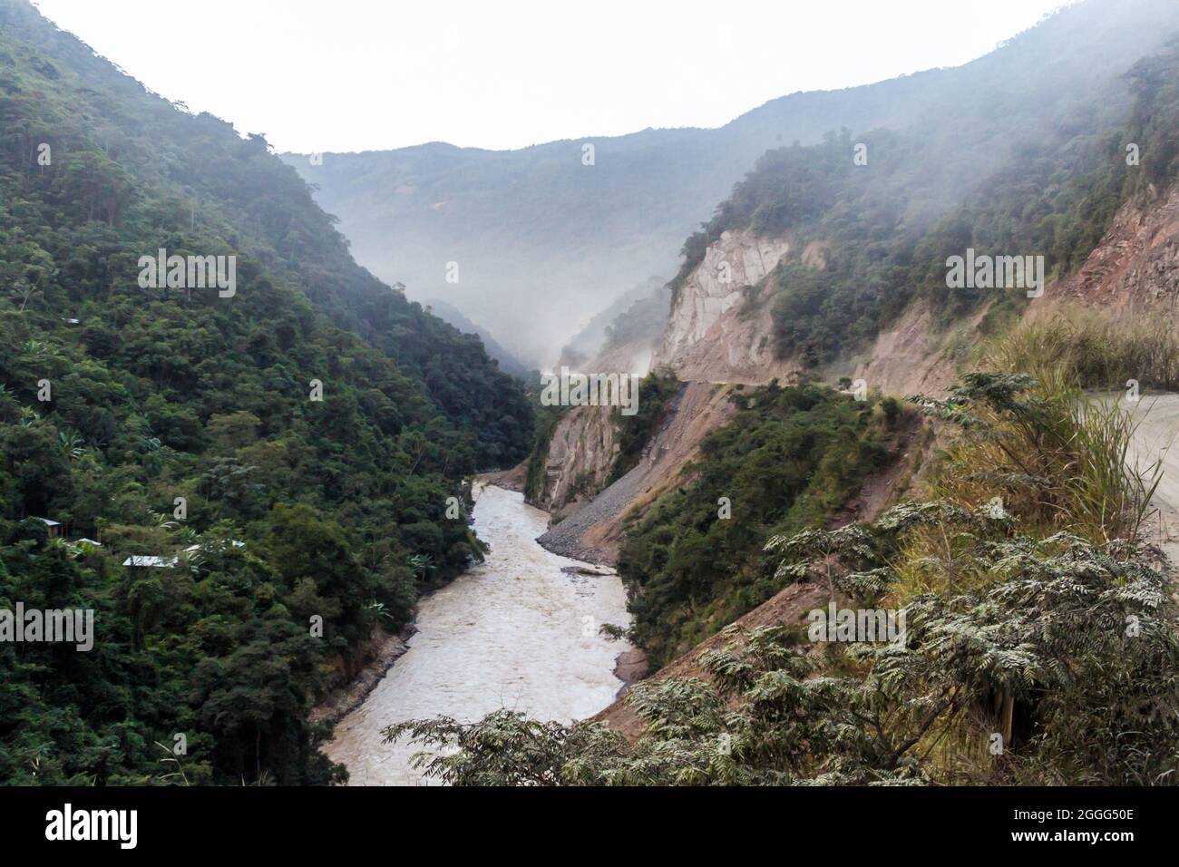 Narrow dangerous road in a valley of Coroico river in Yungas mountains ...