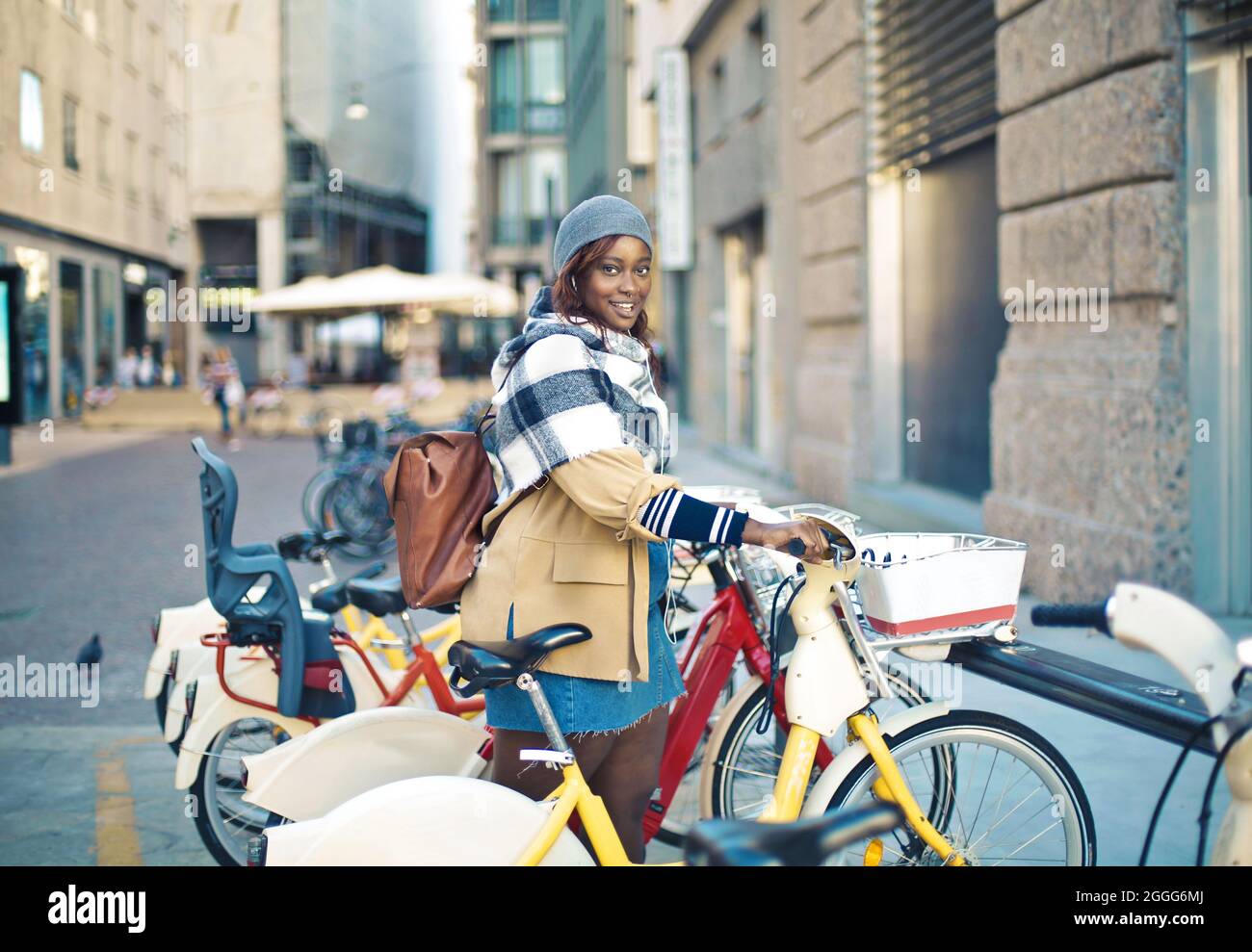 Black woman riding the public bicycle outdoors in autumn Stock Photo ...