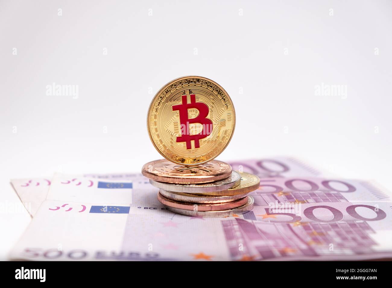 Golden Bitcoin coin entered with logo symbol in red colour on top of ...