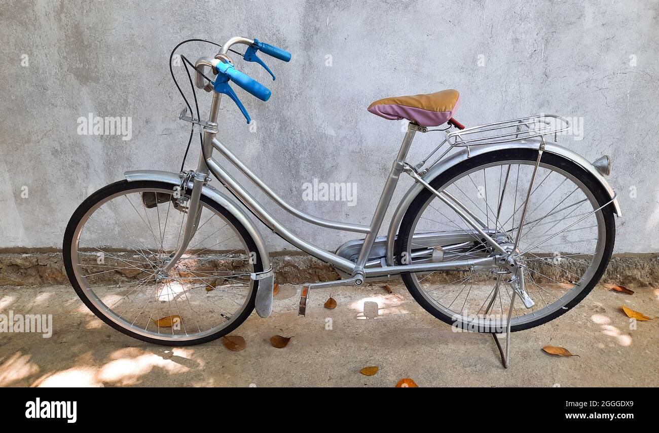 Side view of a silvery color bicycle parked near to a building Stock ...