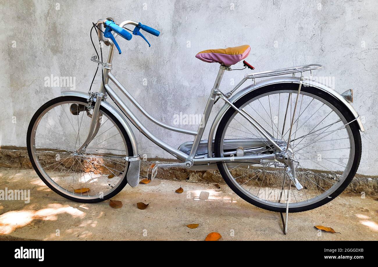 Side view of a silvery color bicycle parked near to a building Stock ...