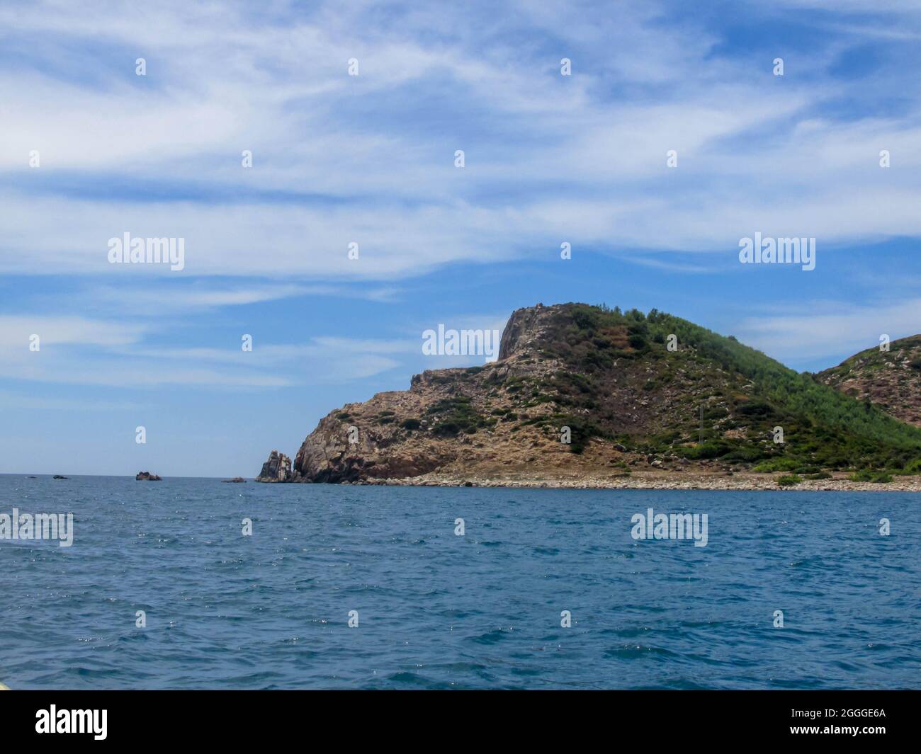 Rocky mountain range shaped like a dog's head protruding from the sea ...