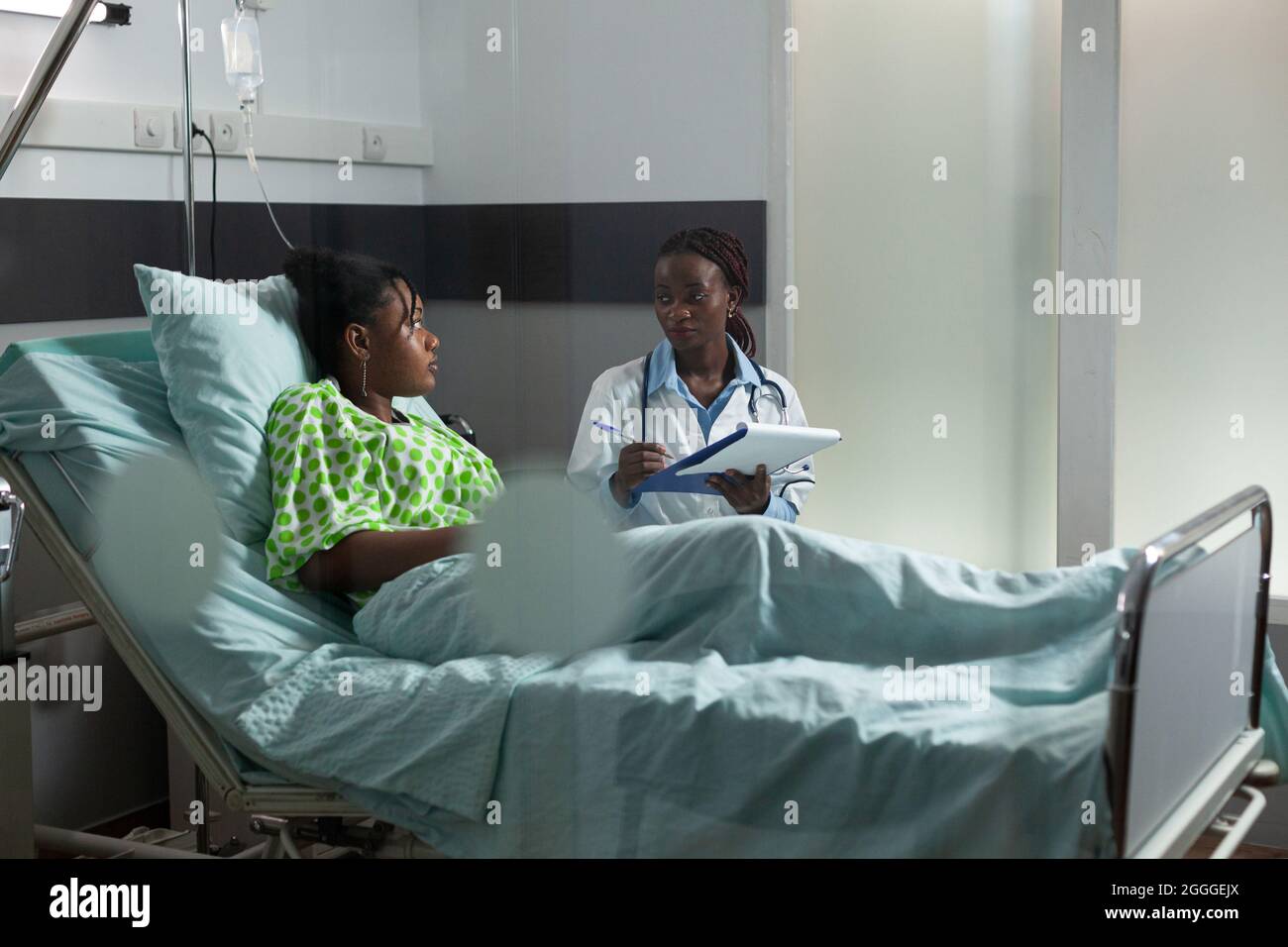African american young adult with disease talking to doctor while ...