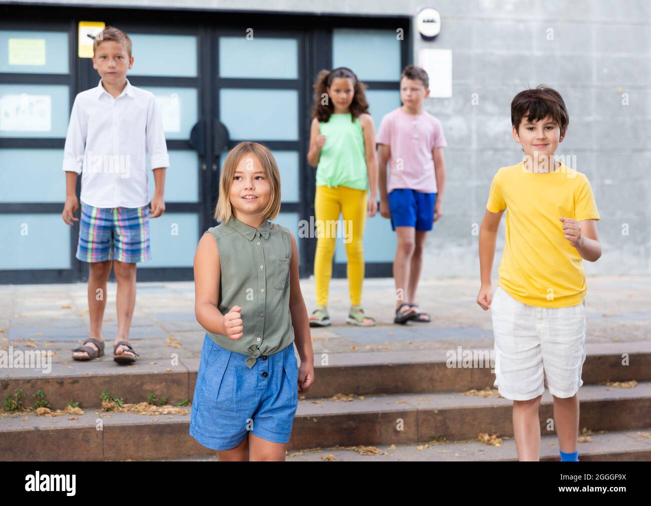 Confident tweens walking along city street on summer day Stock Photo ...